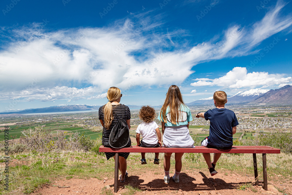 Family adventure together Rear view photo. Sitting on top of a hill ...