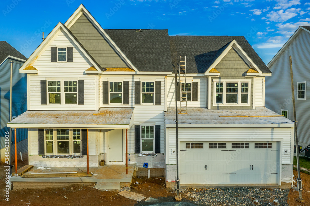 Final touches are added to a new single family home covered with white ...