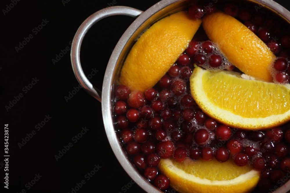 Stewed oranges and cranberries. Stewed fruit is on the stove in the pan ...