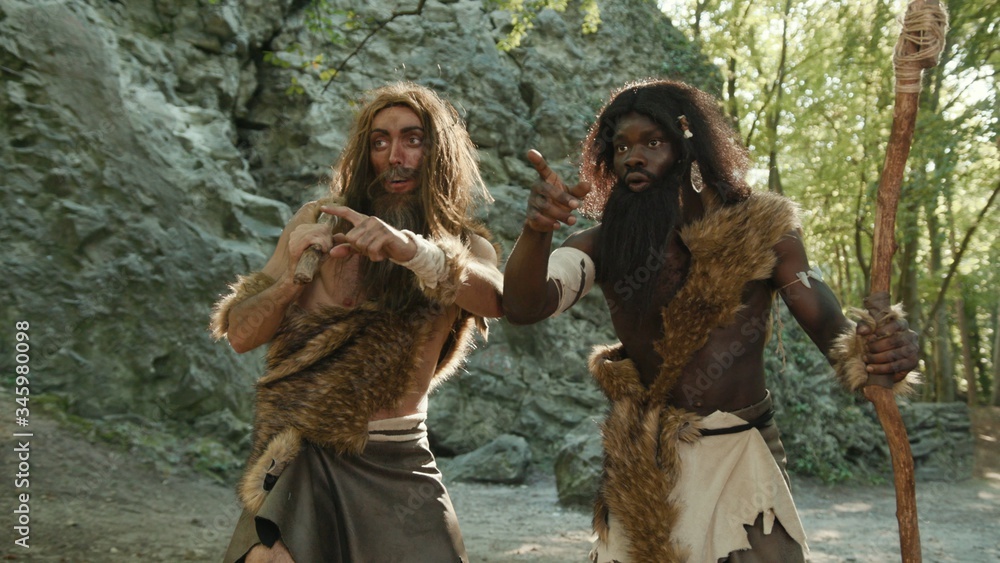 Prehistoric wild tribesmen hunting for food searching animals in green ...