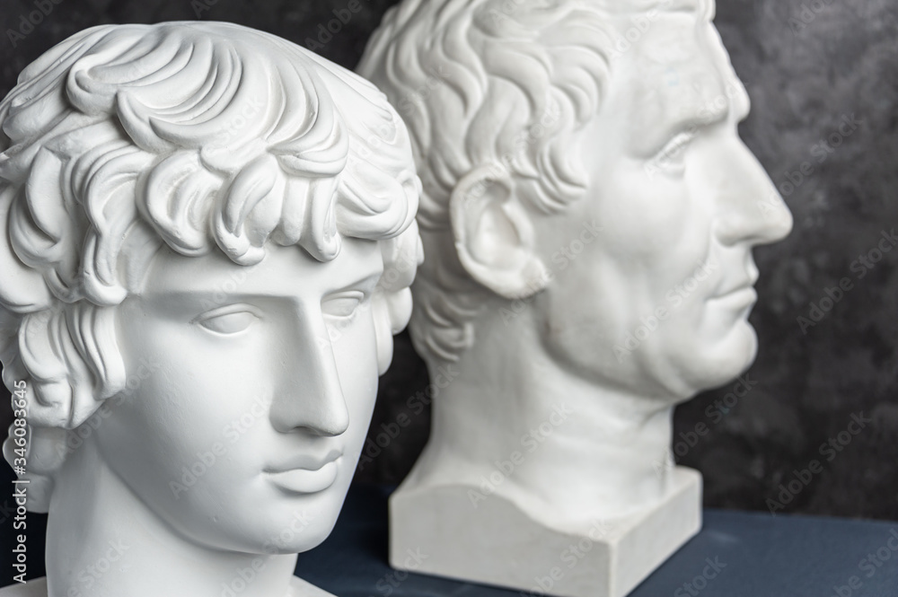Group gypsum busts of ancient statues human heads for artists on a dark ...