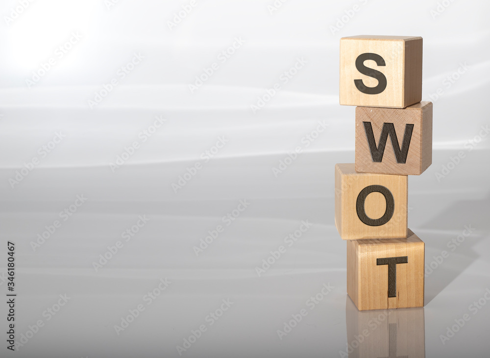 Four wooden cubes with text SWOT (meaning Strengths, Weaknesses ...