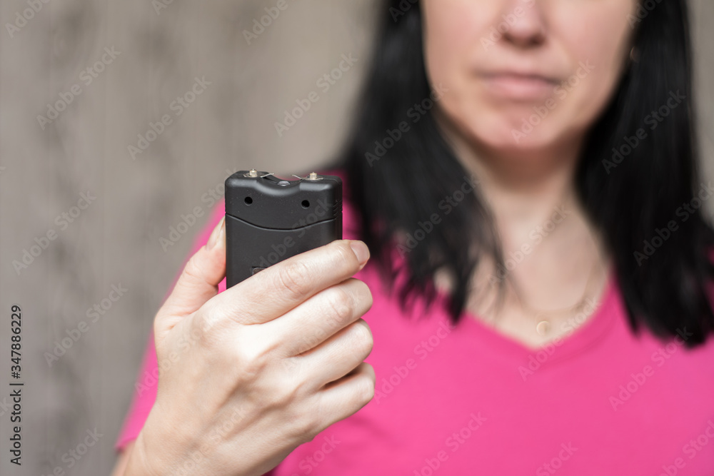 Stock-Foto „The girl holds a personal taser in her hands to protect ...