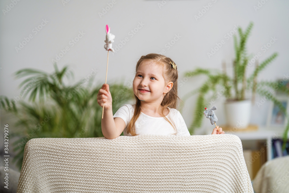 little girl is playing theater. Finger puppets dressed on sticks held ...