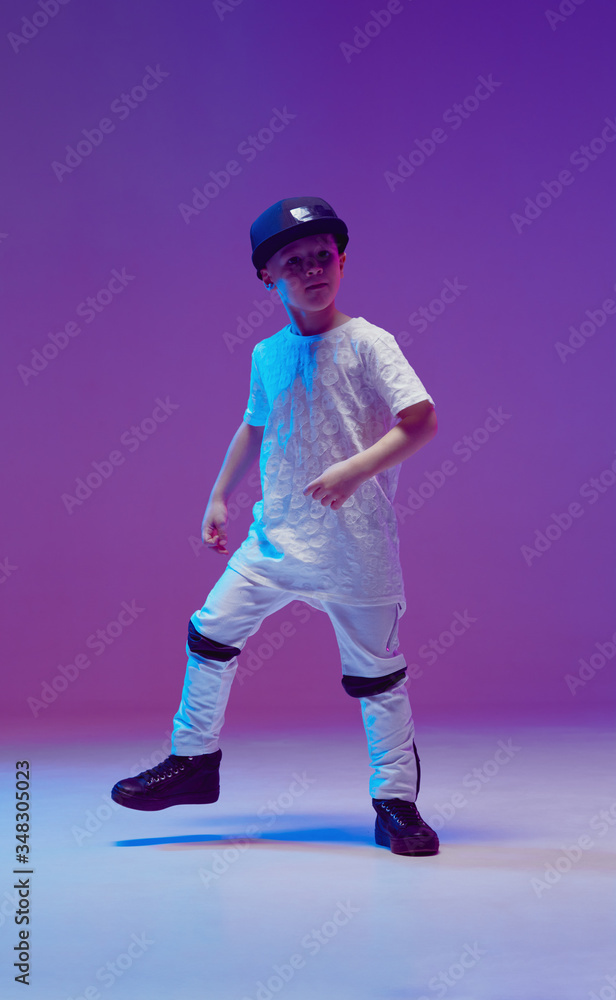 Cool young boy child dancing hip hop in the Studio against the ...
