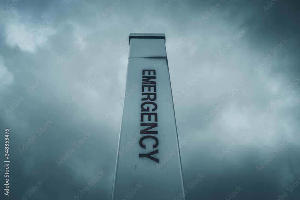 Isolated Emergency sign pole with moody sky background. Hospital alert ...