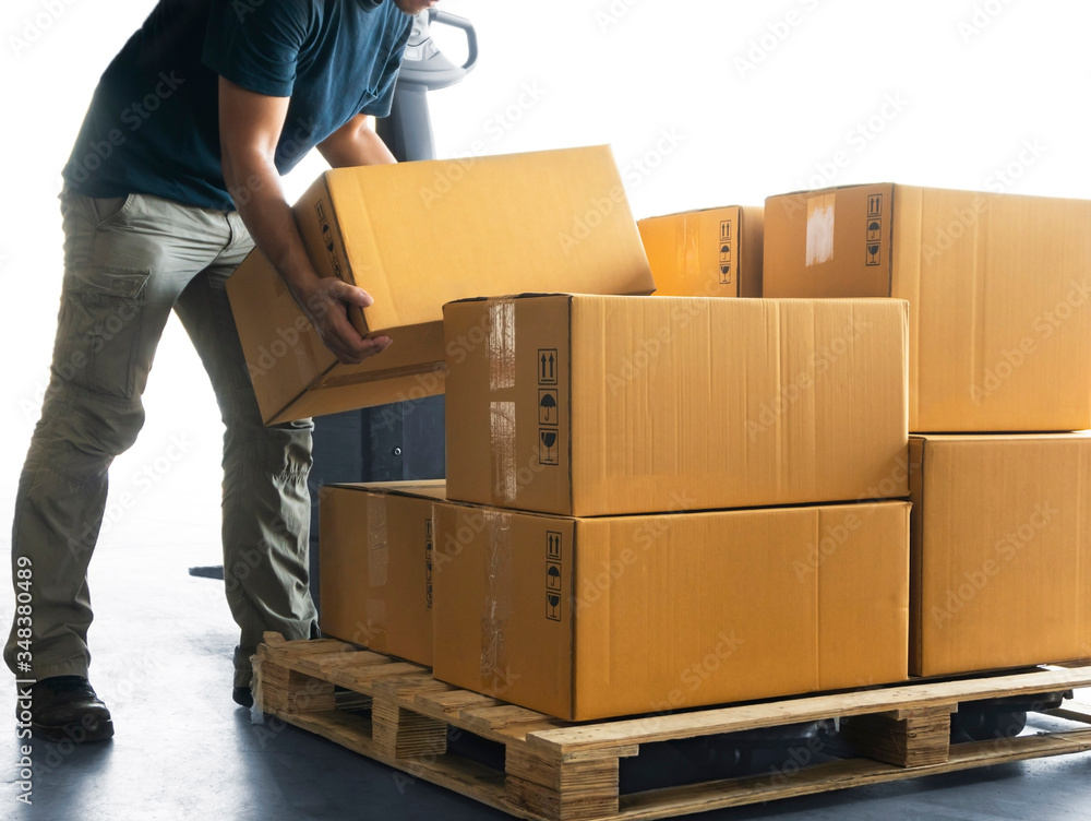 Workers Lifting Packaging Boxes on Pallets Racks in The Warehouse ...