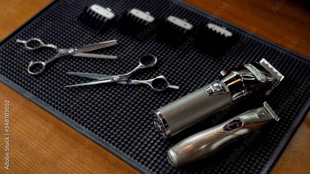 Scissors, electric hair trimmers and four different nozzles lying on a ...