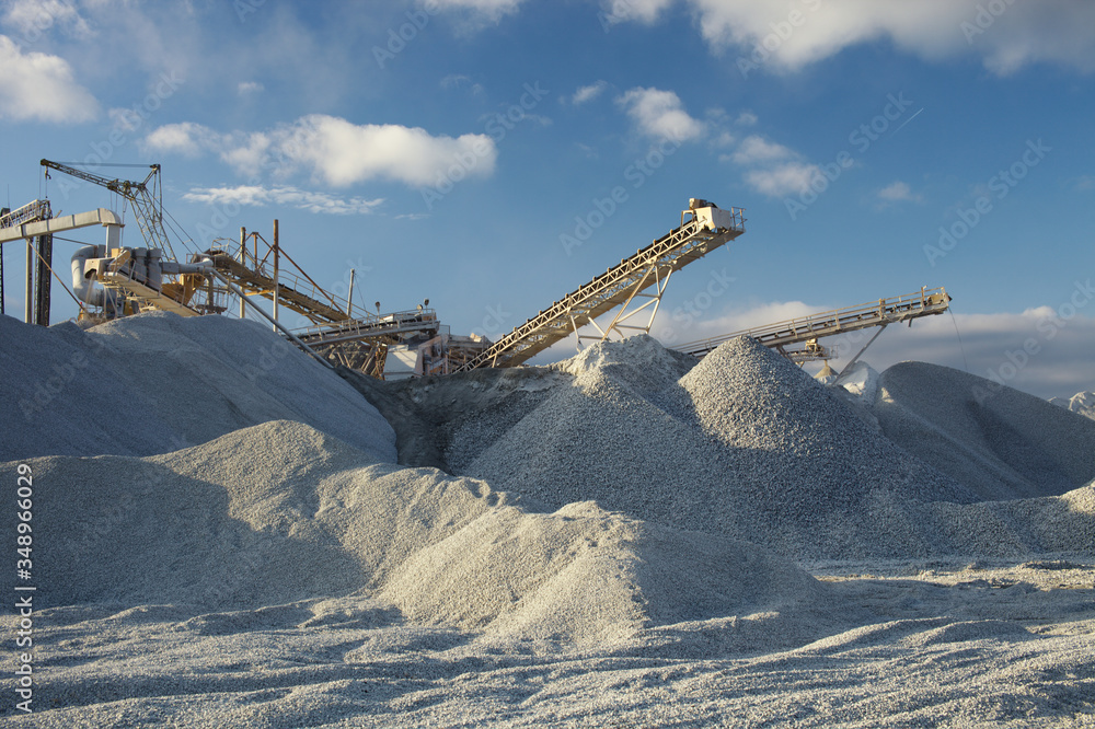 Bulk hills of crushed stone near a crusher plant on a background of ...