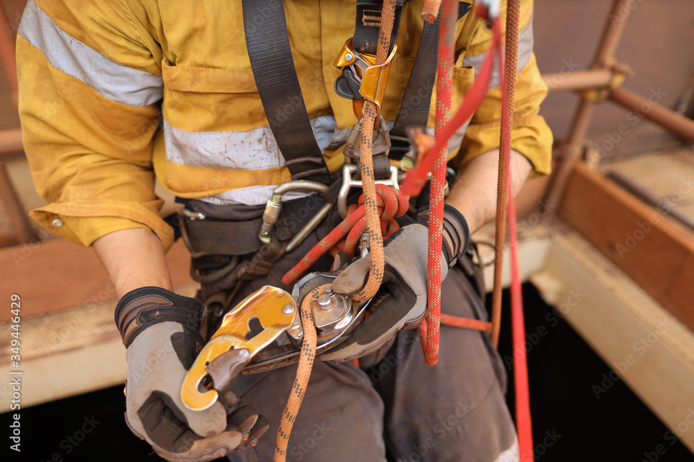 Rope access technician performing transferring his working rope from ...