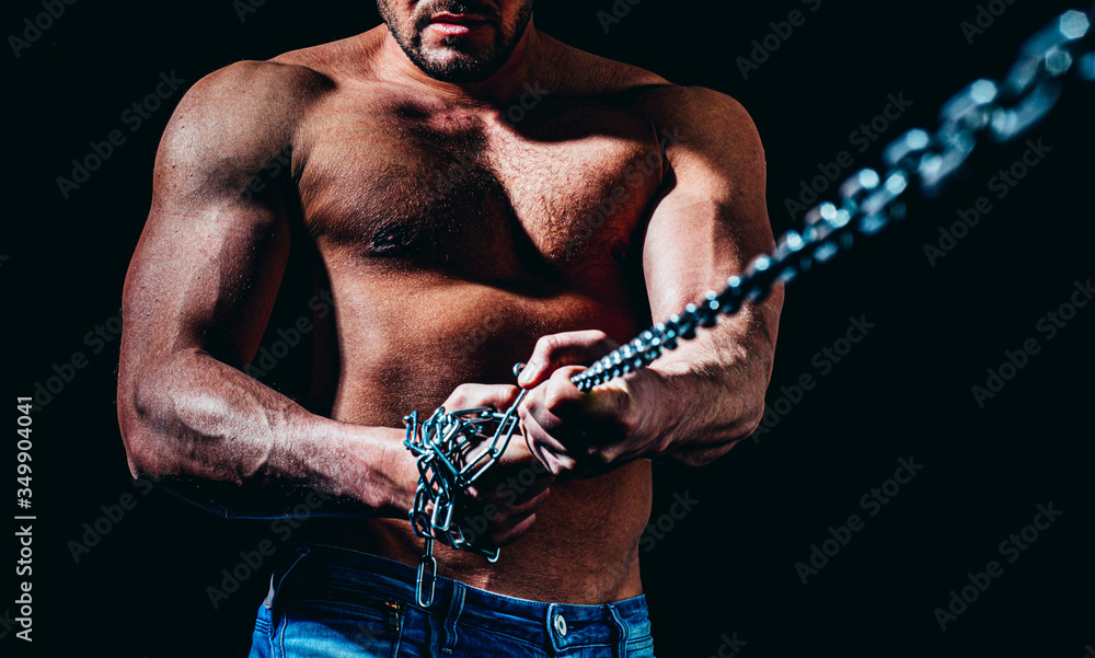 Strong bodybuilder with broken chains, perfect abs, shoulders, biceps ...