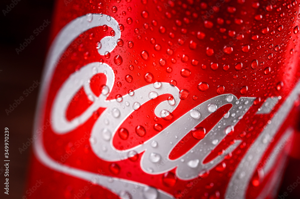 A can, tin of fresh Coca Cola drink with brick wall backround. Coca-Cola company is the most ...