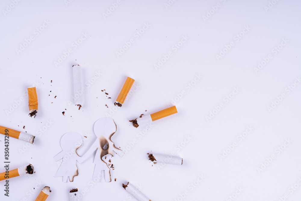 Paper cut of family members destroyed by cigarette on white background ...