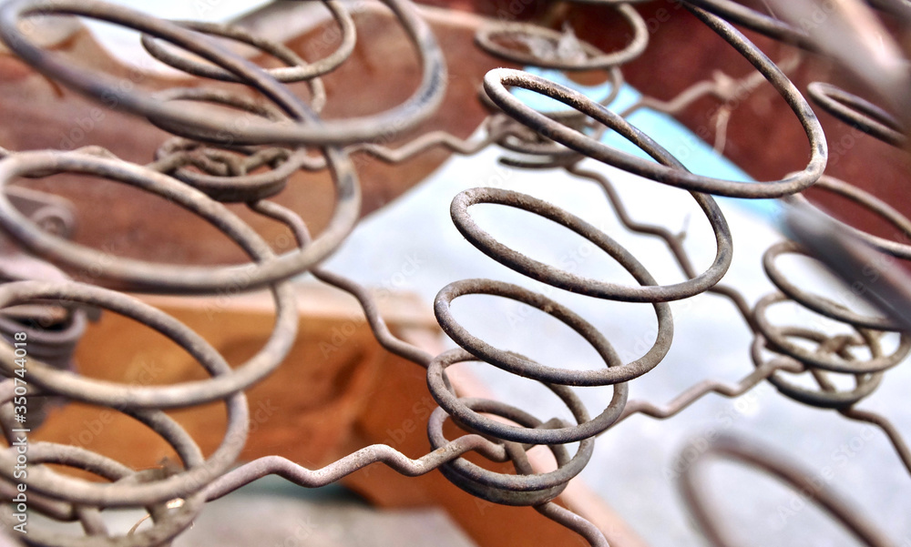 Rusted metal wire chair coils exposed in an antique wooden chair seat ...