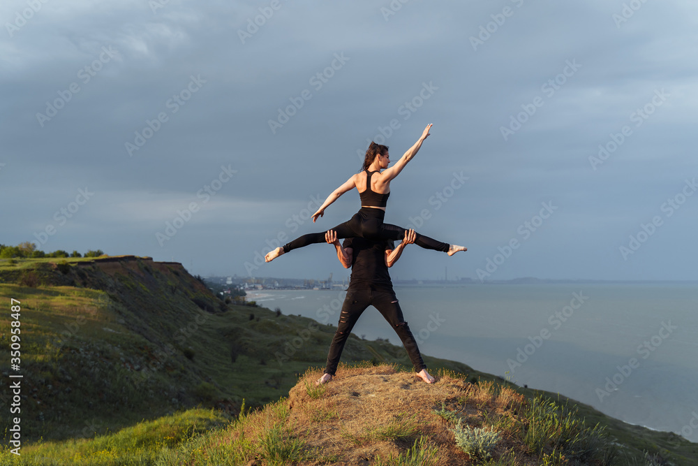 Foto Two young sportsmen doing fitness acro yoga exercise together ...