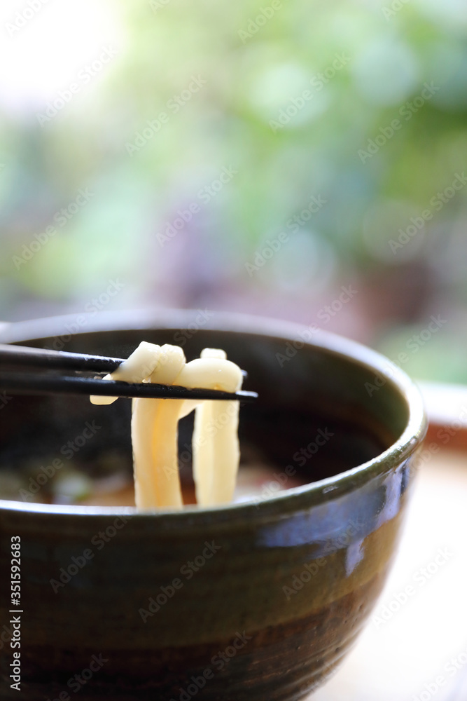 kitsune udon noodles with fish ball and tofu on wood background ...