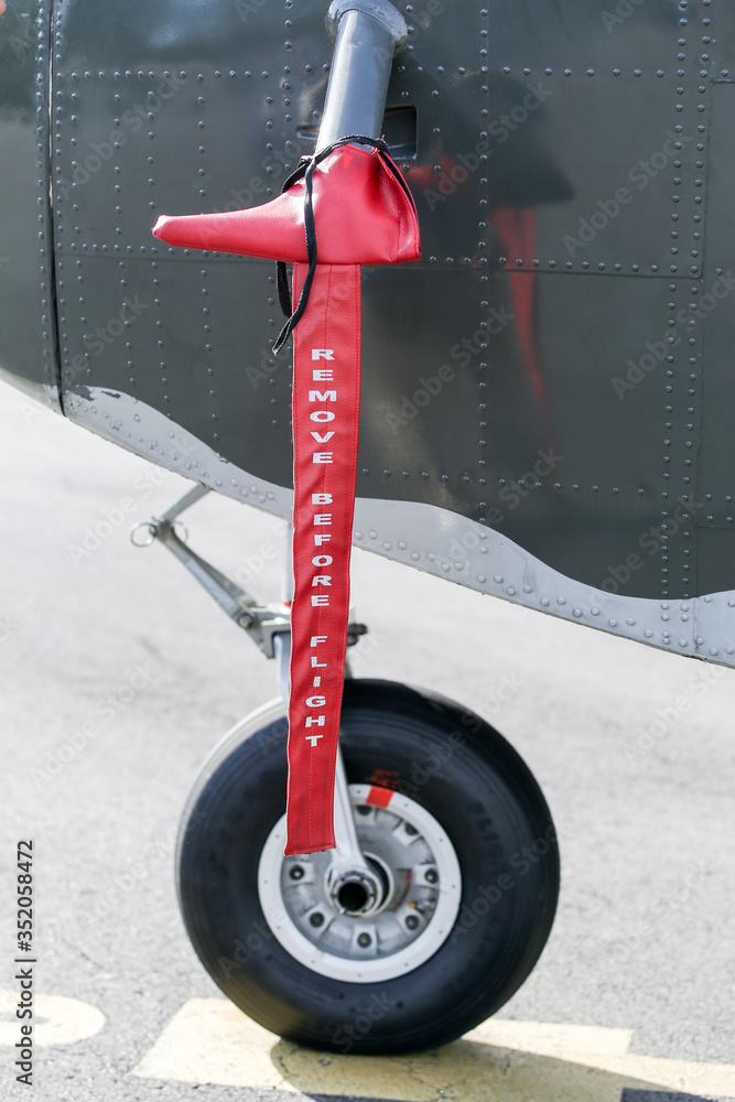 Remove before flight tag sign attached to an aircraft. Warning label ...