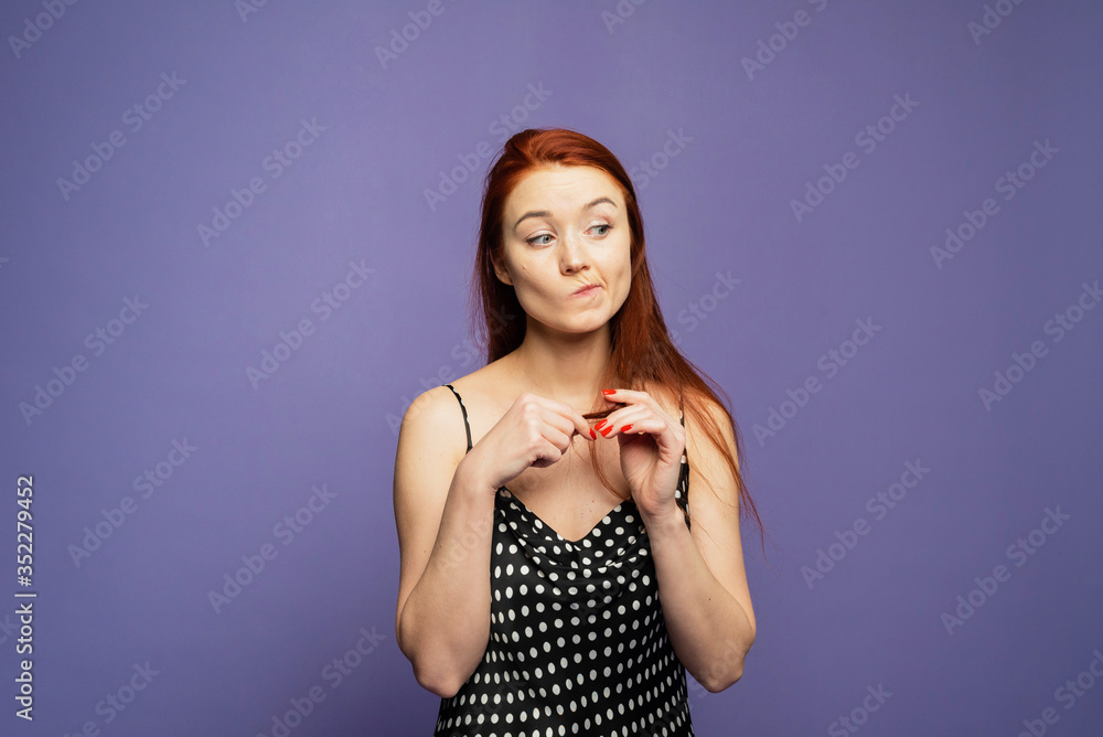 Foto de Stock People and facial expressions. An embarrassed sweet woman wraps her hair around ...