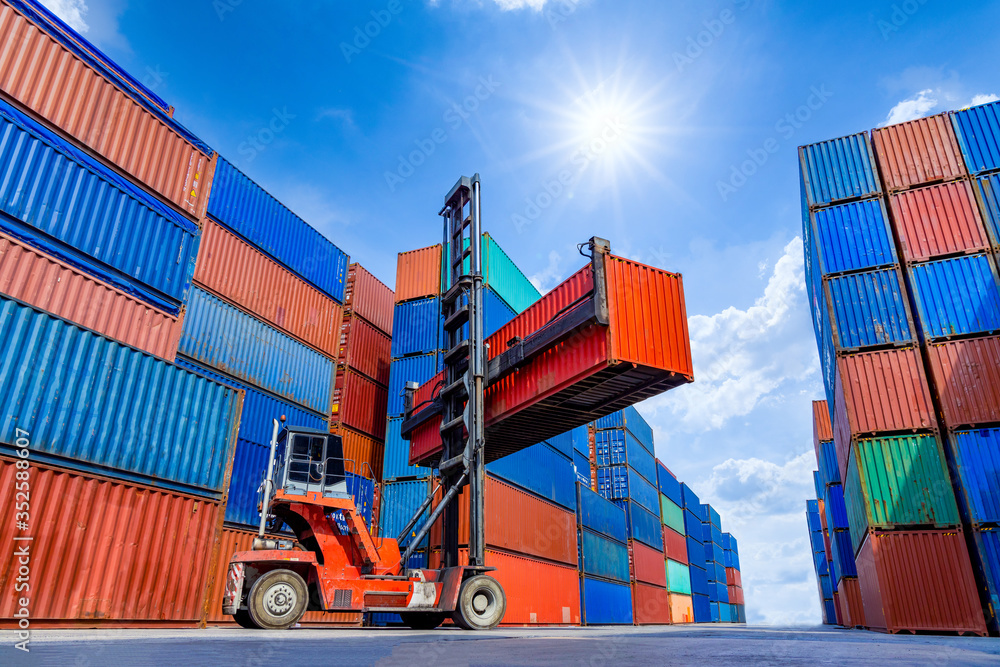 Container stacker crane lifting up stacking container box in yard ...