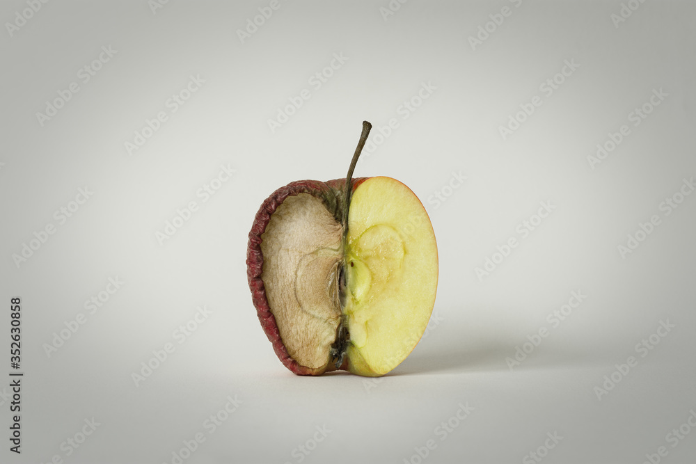 red apple with one half good and the other half rotten, concept of time ...