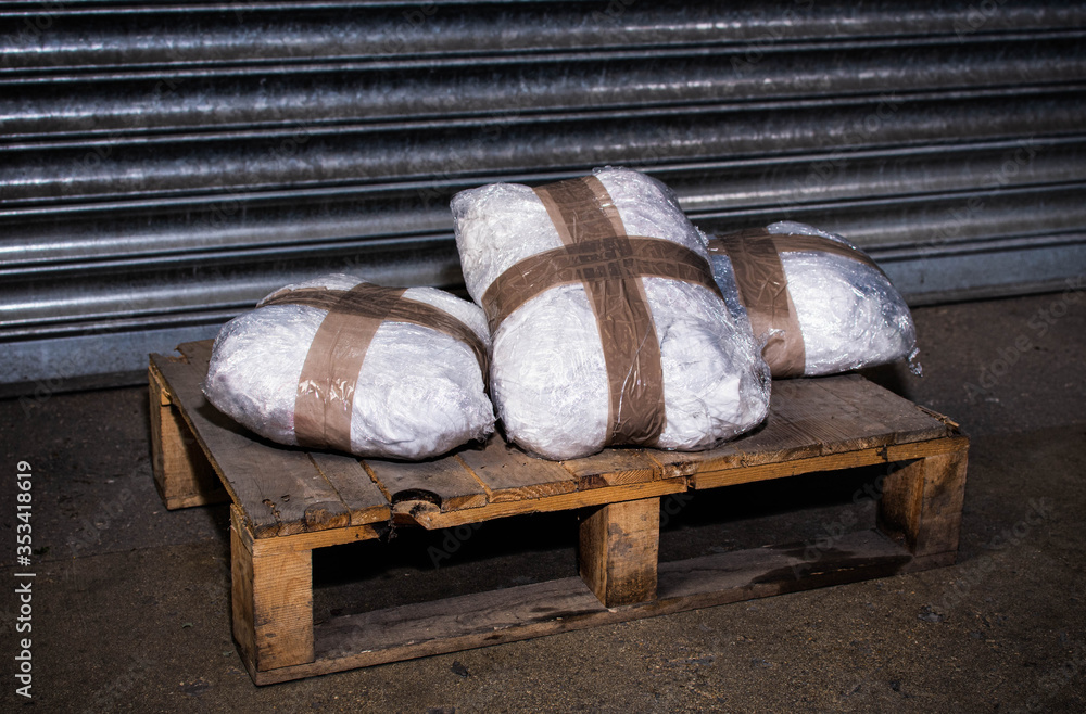 Cocaine or other illegal drug packages sitting on a pallet ready for ...