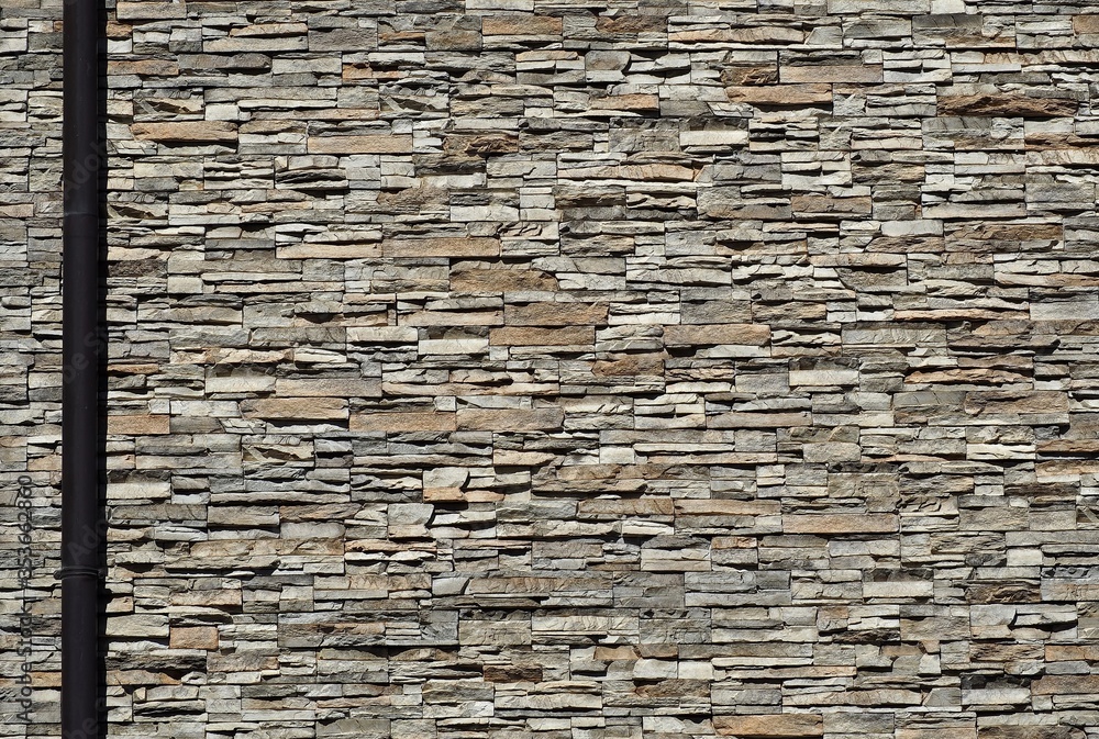 Stone cladding wall made of striped stacked slabs of natural brown and ...
