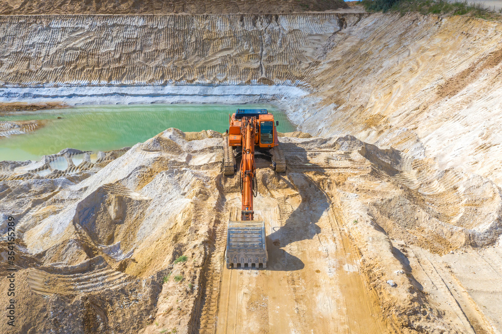 yellow and orange excavator, bulldozer, tractor in a sand pit removed ...
