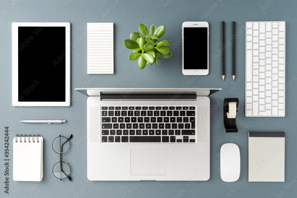 Office desktop with laptop and business accessories on gray background ...