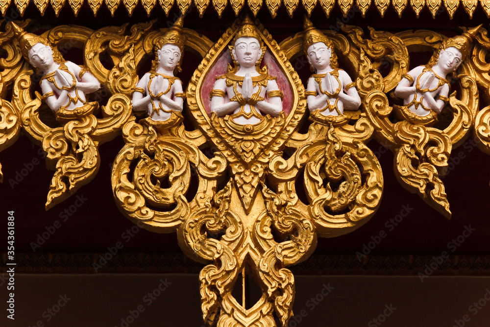 Golden painted wooden detail of a temple building showing various ...