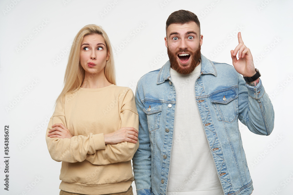 Amazed young handsome bearded brunette guy raising index finger and ...