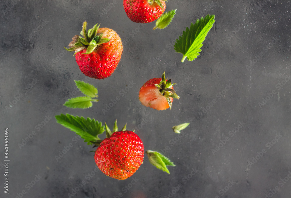 Home grown strawberry flying floating in the air in motion with green ...