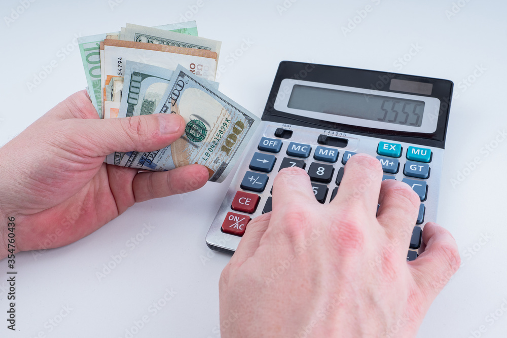 A person holds banknotes in his hands and makes calculations on a ...