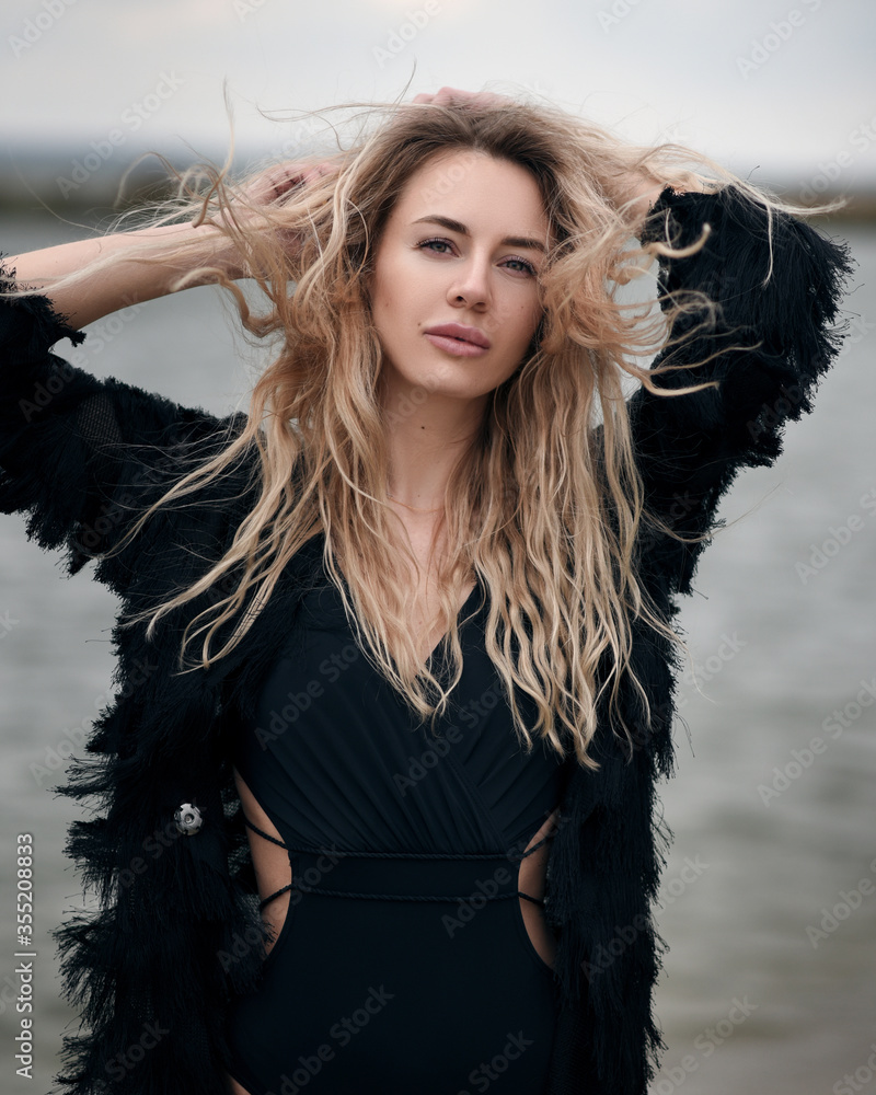 Beautiful young blonde, portrait, looking at the camera, in a black ...