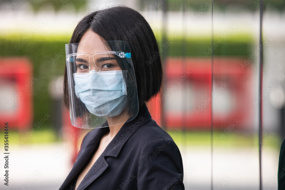 Asian young business woman wearing face shield and mask for healthcare ...