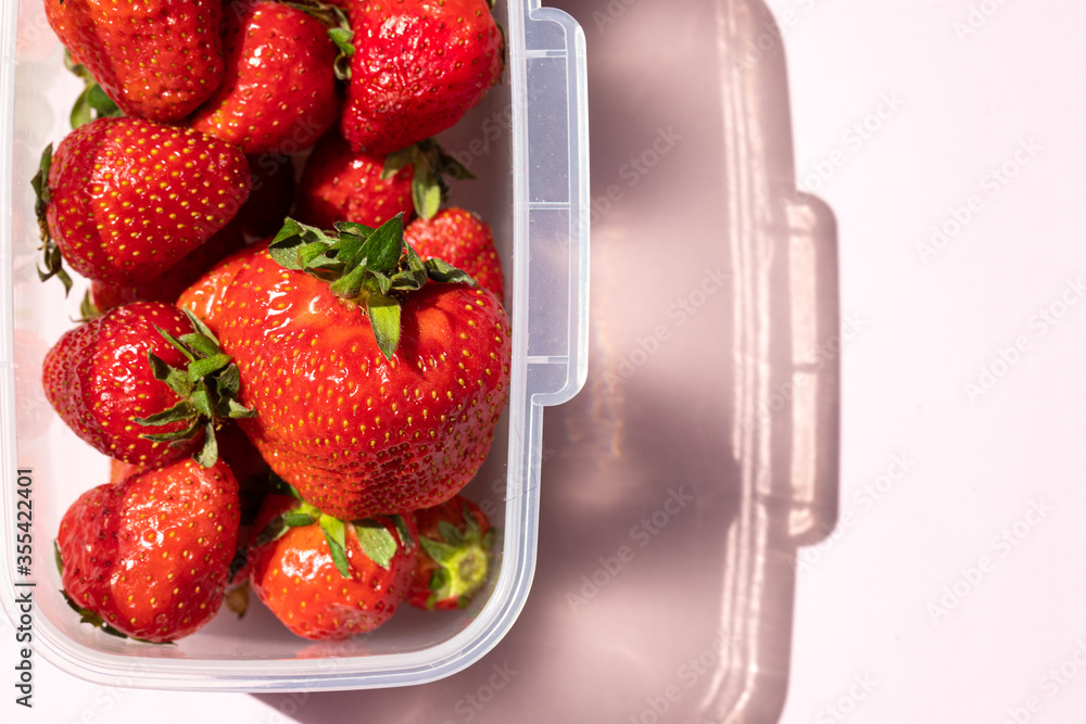 fruit storage concept: strawberries in plastic container close up, top ...
