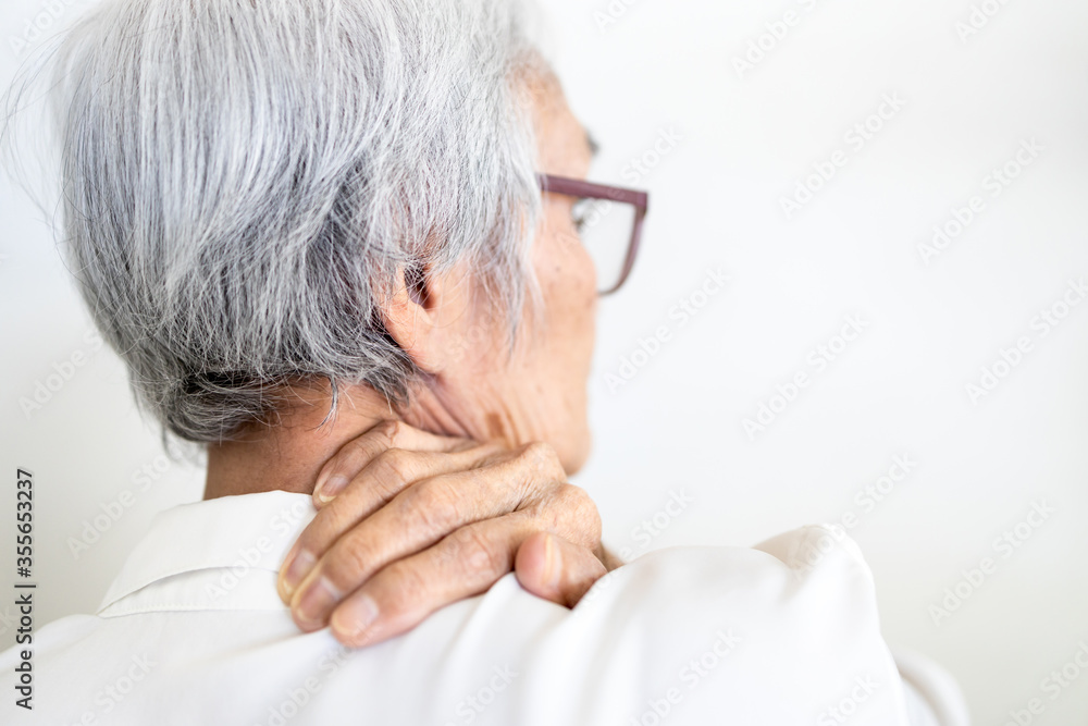 Stockfoto Sick senior woman with back neck and shoulders pain on the ...