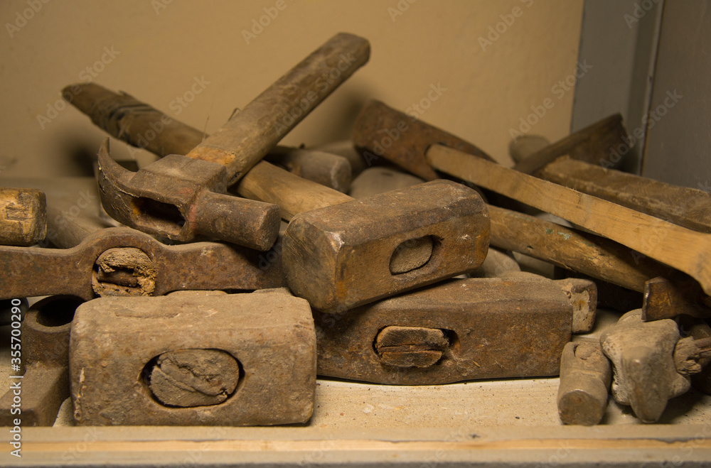 Many iron hammers of different shapes lie in the closet. Large and ...