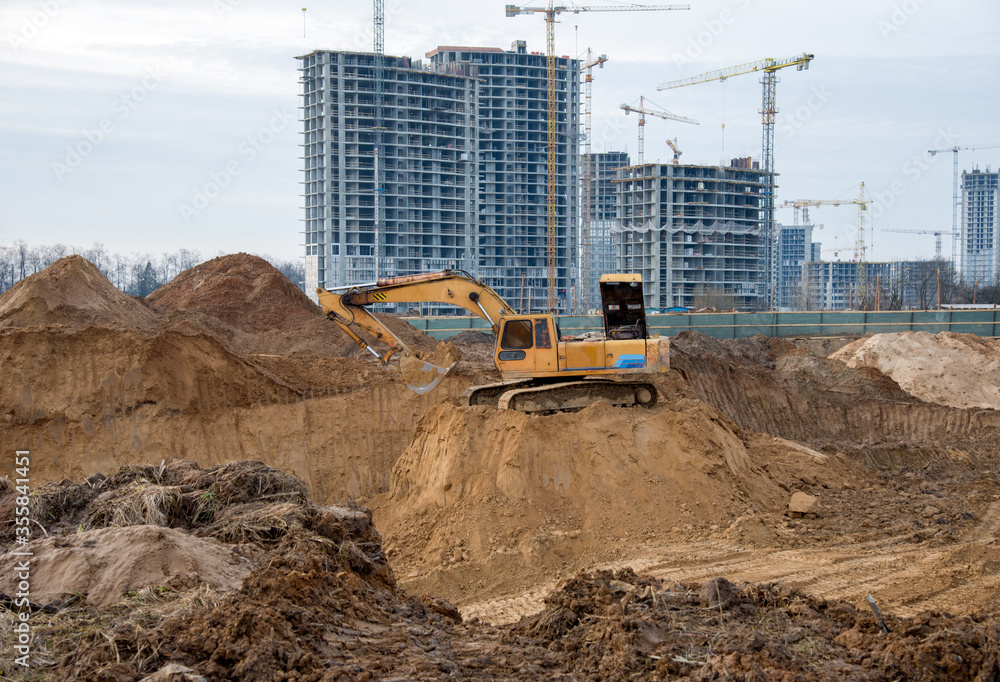Excavator working at construction site. Backhoe digs ground for the ...