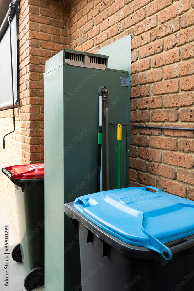 Residential general waste & recycle bins beside hot water service ...
