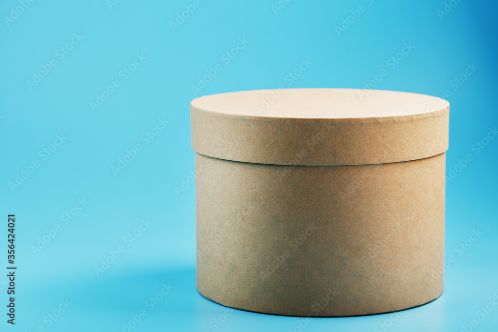 Round cardboard box on a blue background, free space. Stock Photo ...