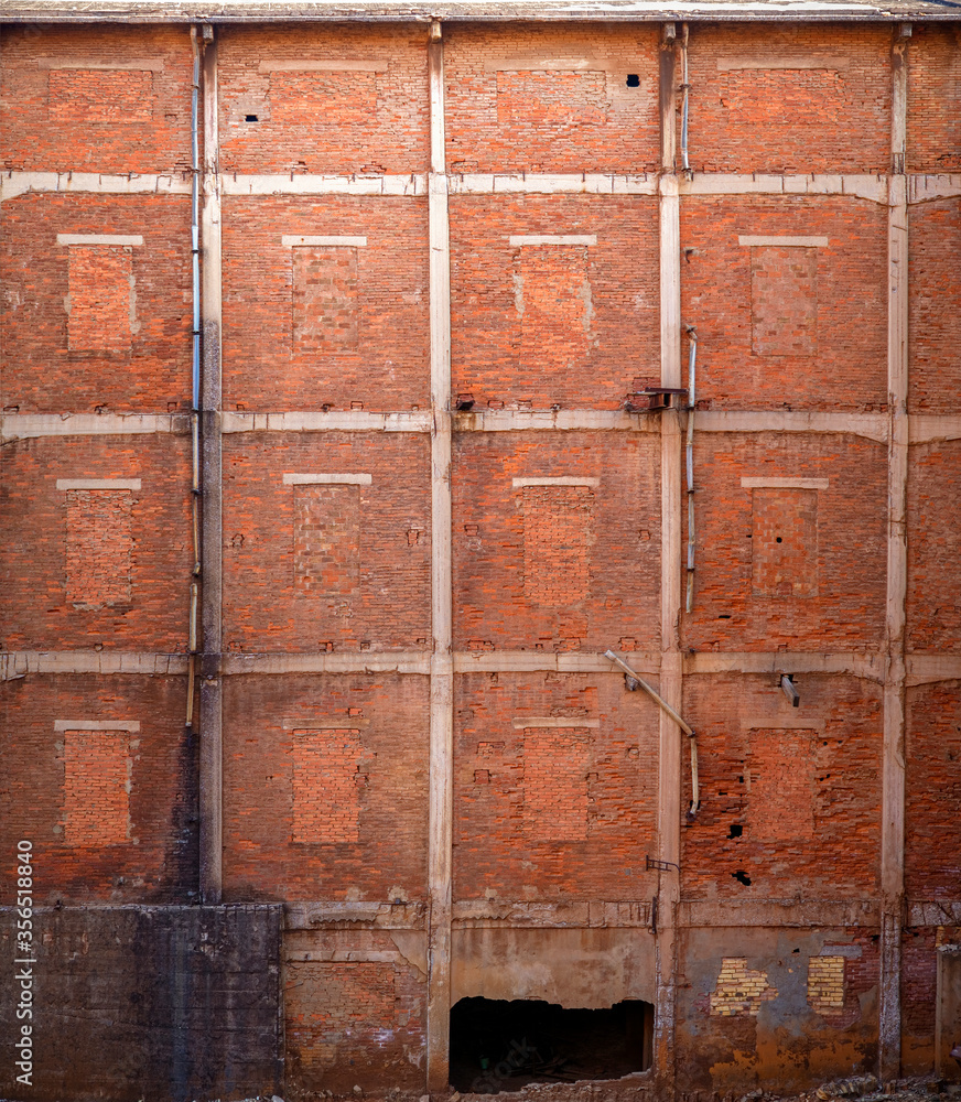 Shabby old high wall of abandoned red brick building with brick windows ...