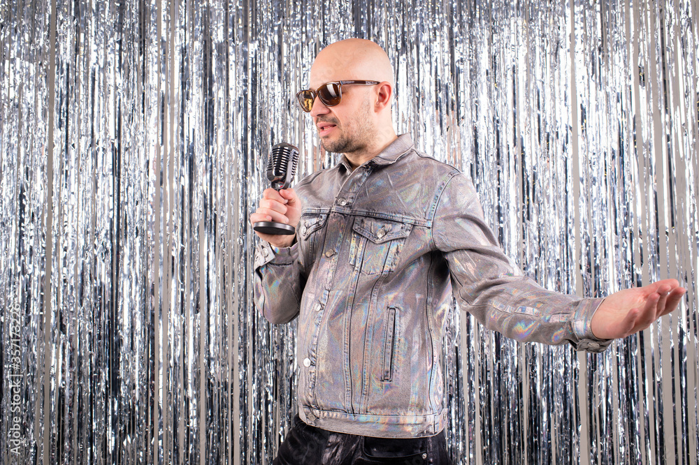 The 90s singer, wearing a silver shirt and leather pants, sings songs ...