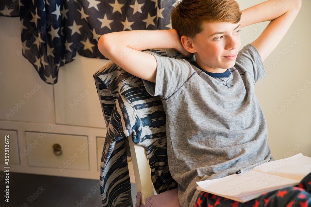 Confident boy doing homework with hands behind head Stock Photo | Adobe ...
