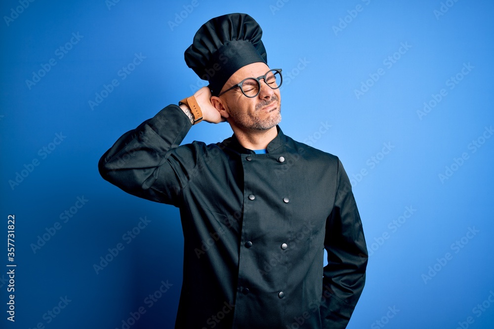 Young handsome chef man wearing cooker uniform and hat over isolated ...