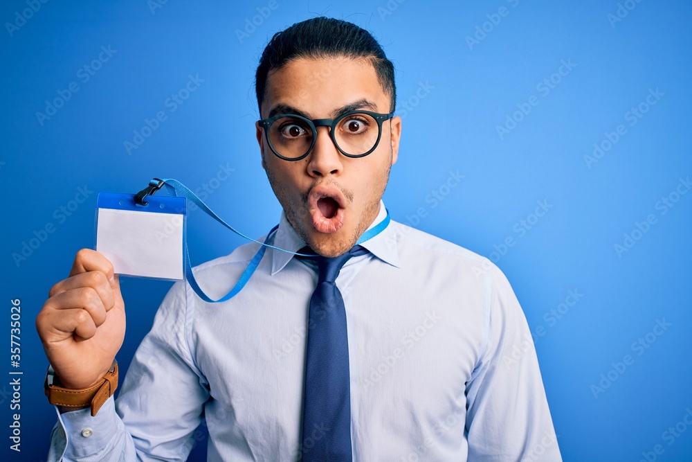 Young brazilian call center agent man holding id identification card ...