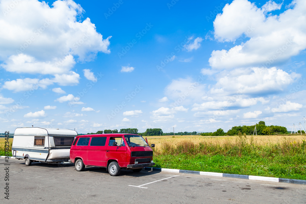 Old burgundy van with a family trailer of a mobile home on the ...