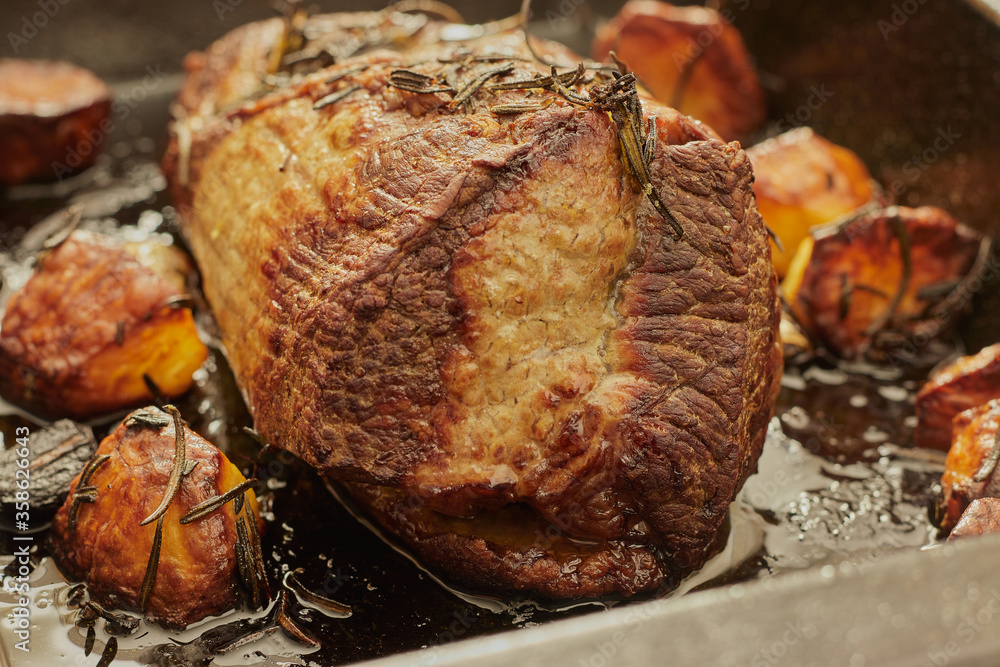 Roasted joint of beef and roast potatoes,resting in oven tray. Stock ...