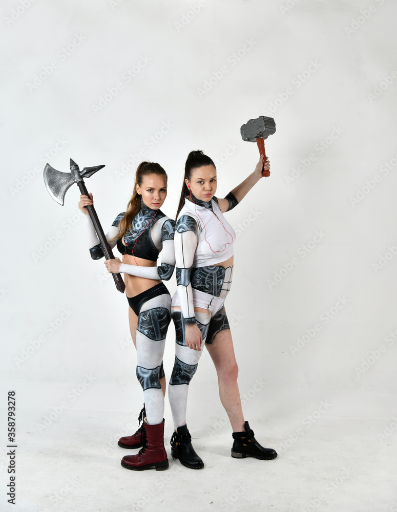 beautiful brunette girls in robotic costumes fight on battle axes and hammers Stock Photo ...