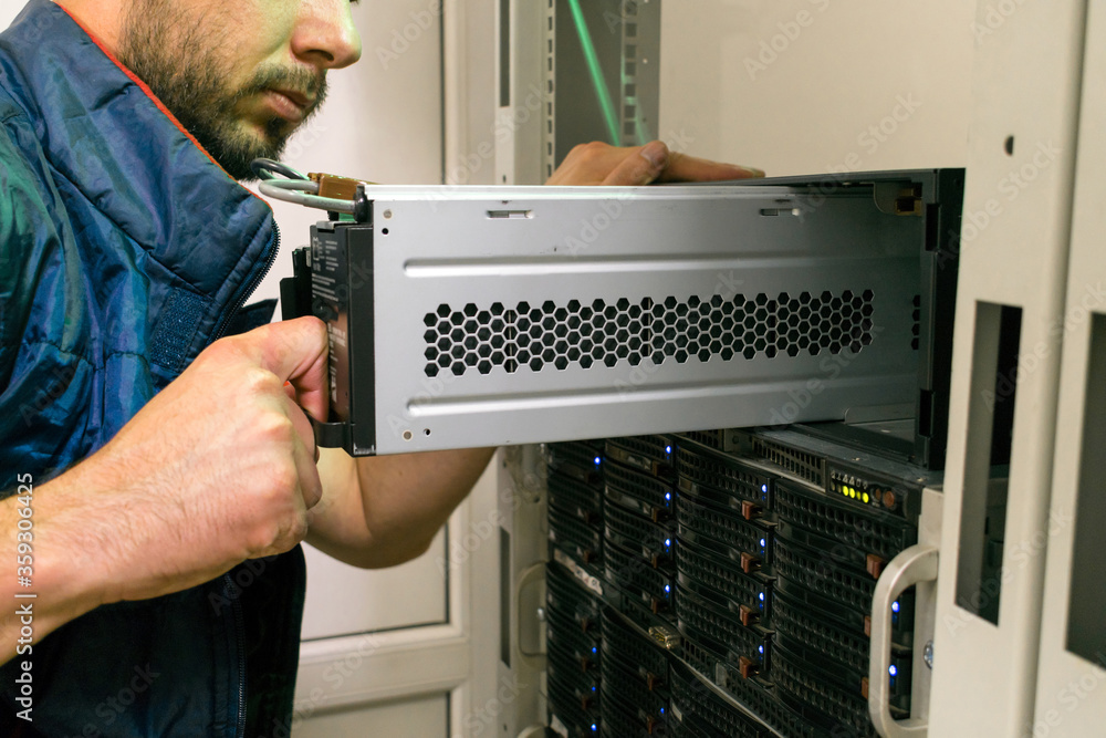 Maintenance of data center equipment. The technician installs a new ...