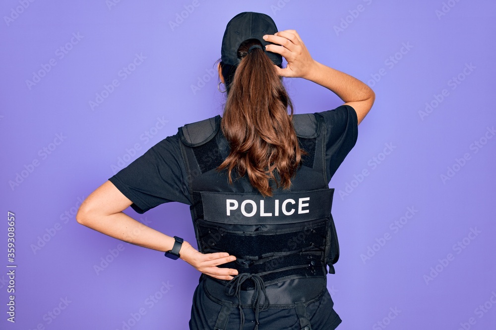 Young police woman wearing security bulletproof vest uniform over ...